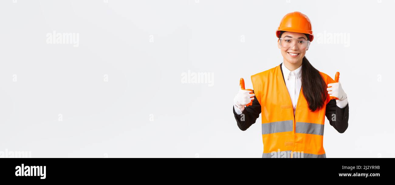 Satisfied smiling female asian chief construction engineer giving ...