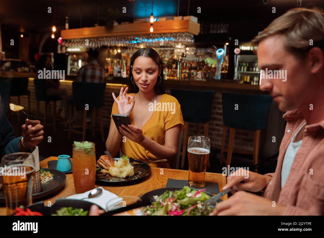 friends out for dinner women taking pictures of meal and drink Stock ...
