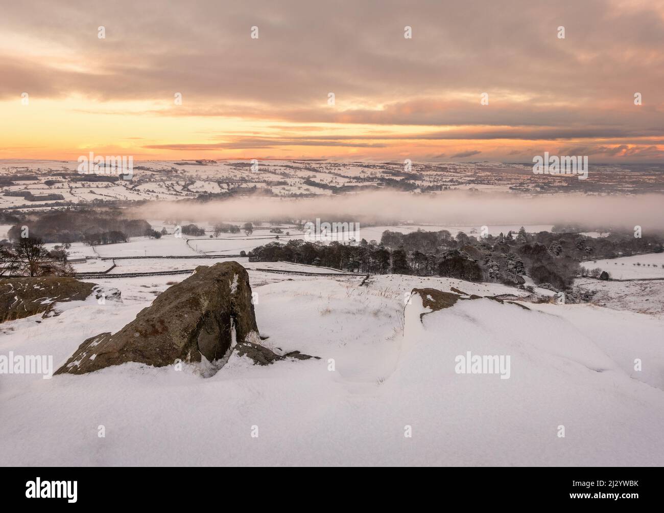 Snow covered moors at sunset above Burley-in-Wharfedale with a light ...