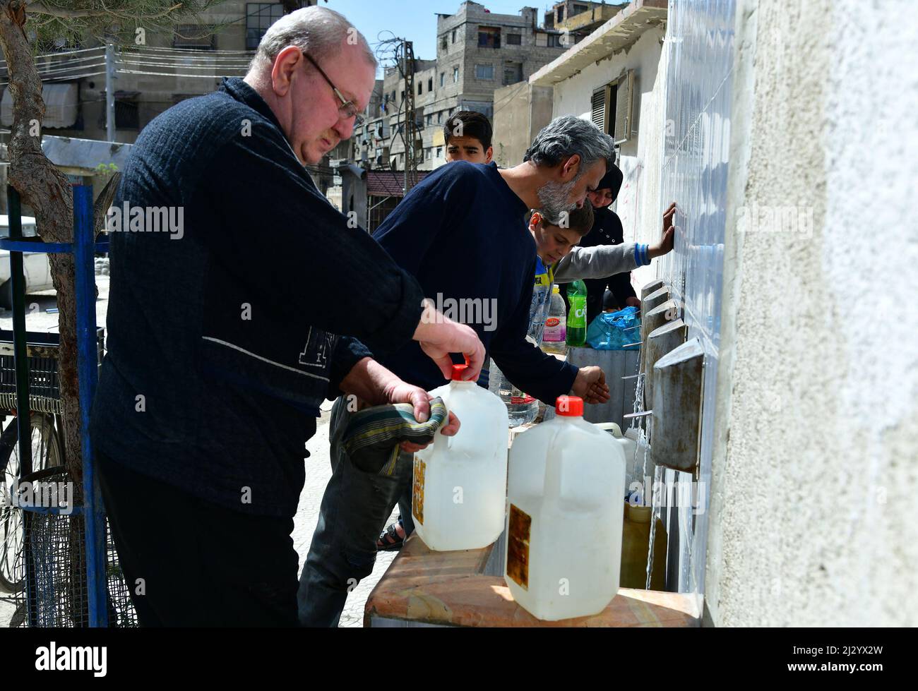 Damascus, Syria. 4th Apr, 2022. People fill their bottles with water at ...