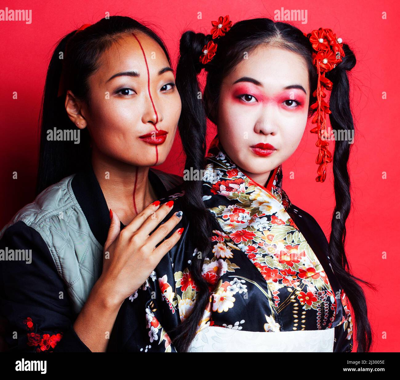 two pretty geisha friends: modern asian woman and traditional wearing ...