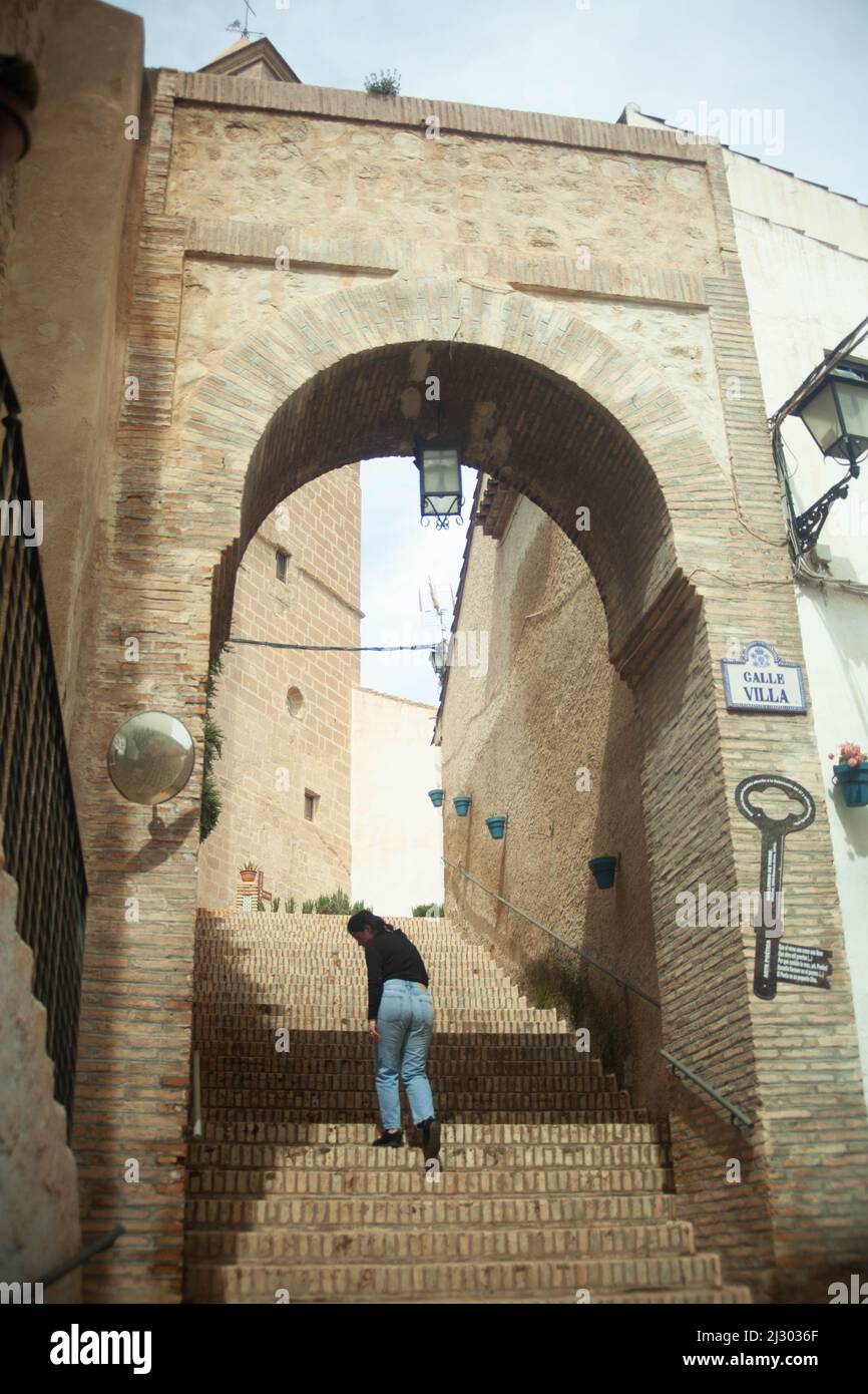 A back view of a woman looking around while walking up stairs of old ...