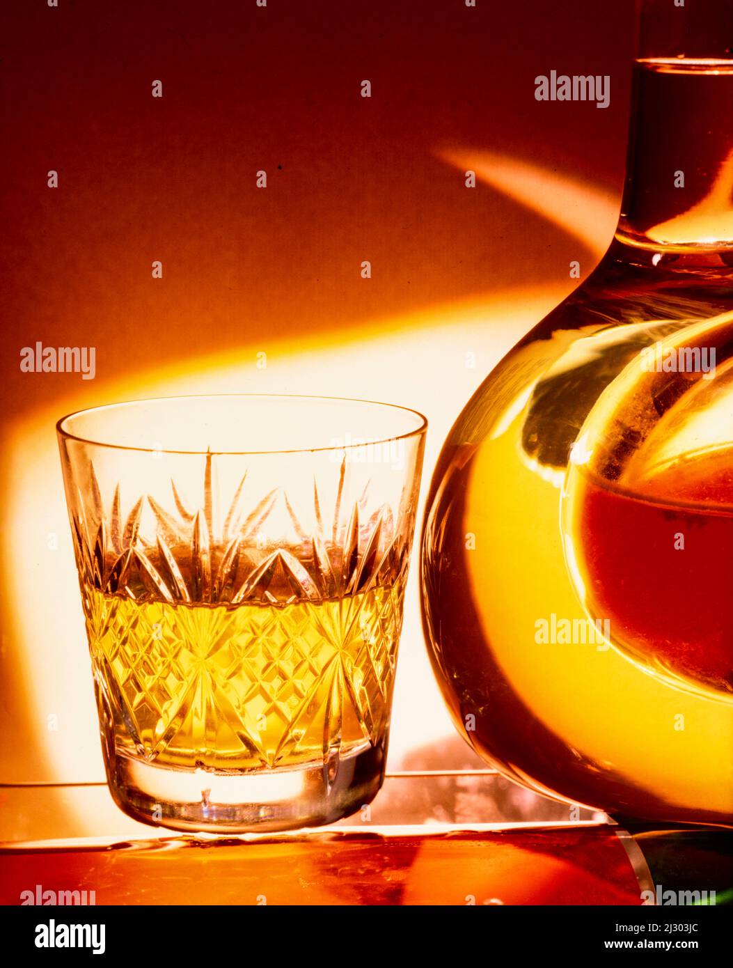 Creative abstract still-life of glass bottle with colour, and a cut ...