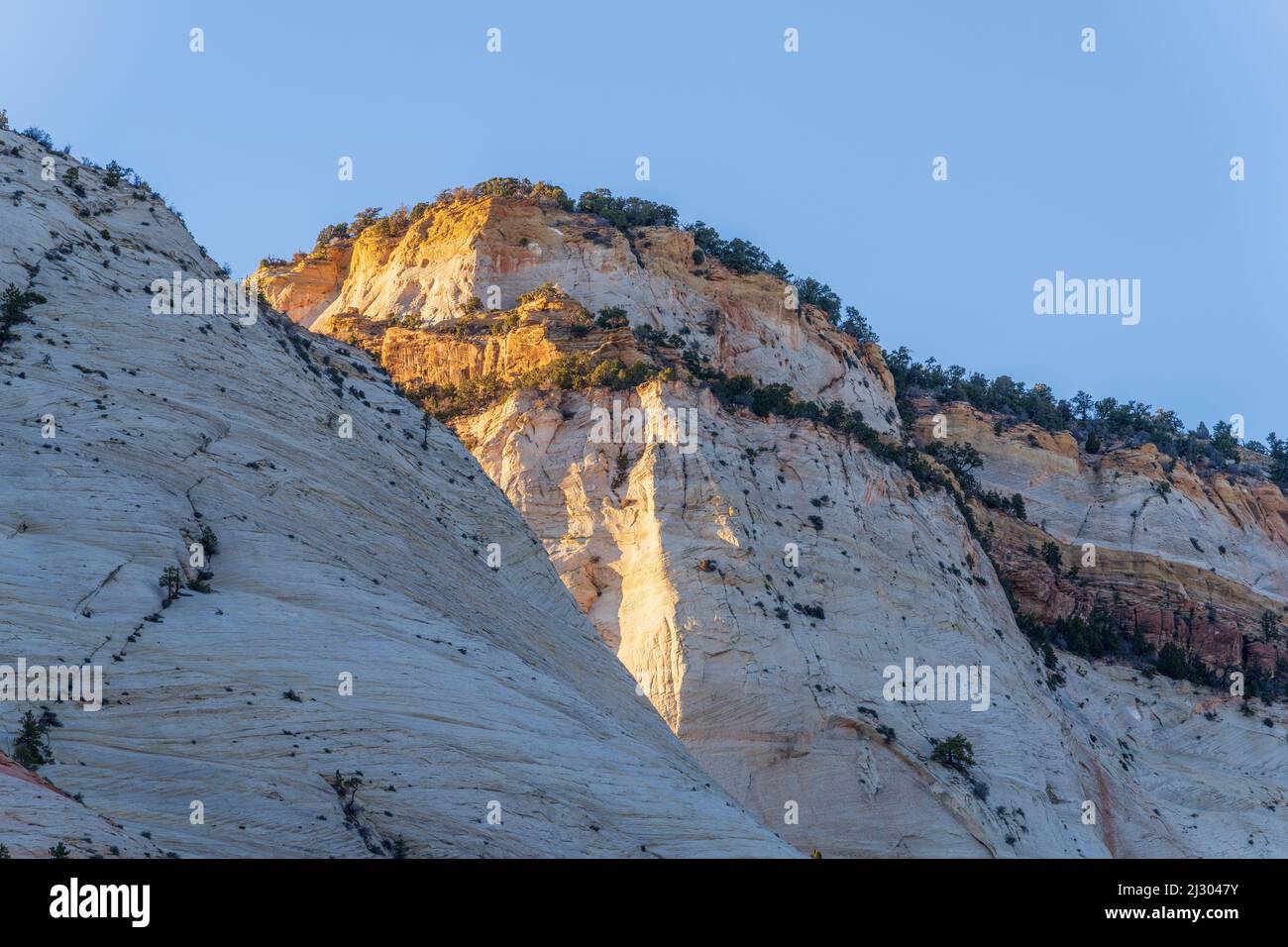 A beautiful shot of sunlight dripping on a cliff in Zion National Park ...