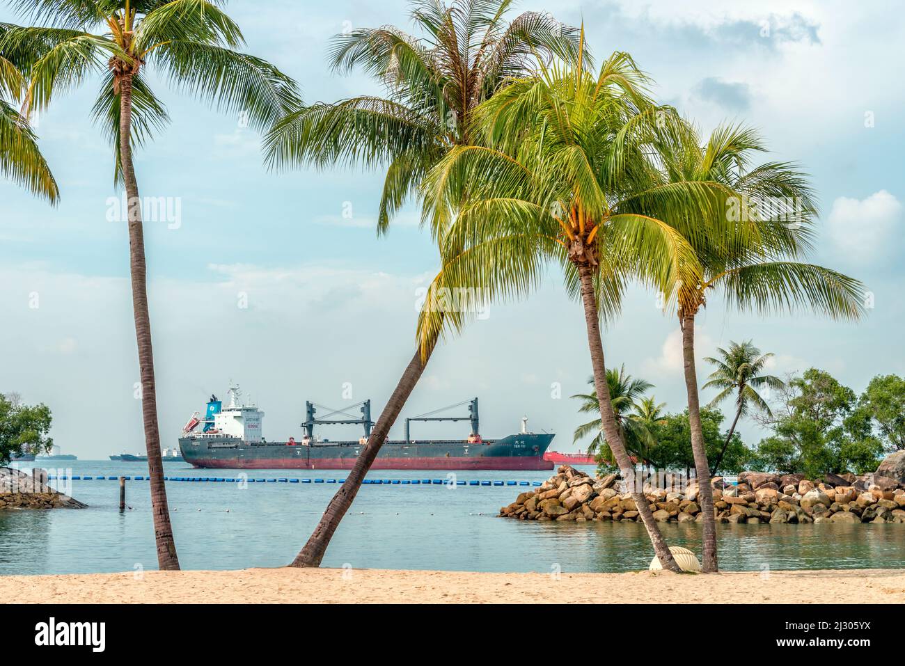Palawan Beach on Sentosa Island, with a cargo ship in the roadstead in ...