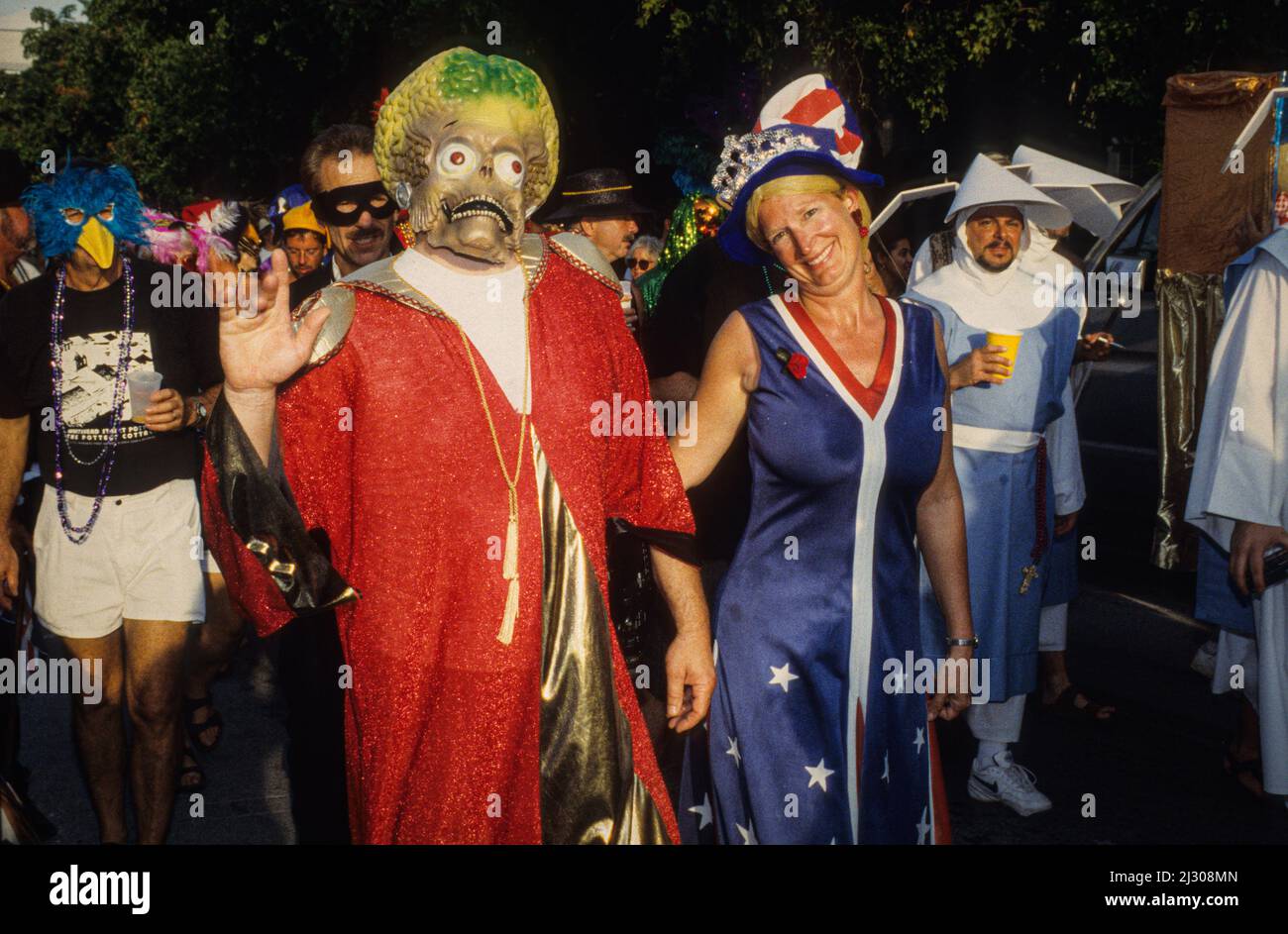 An alien says hello to America. Participants in colourful costumes at ...