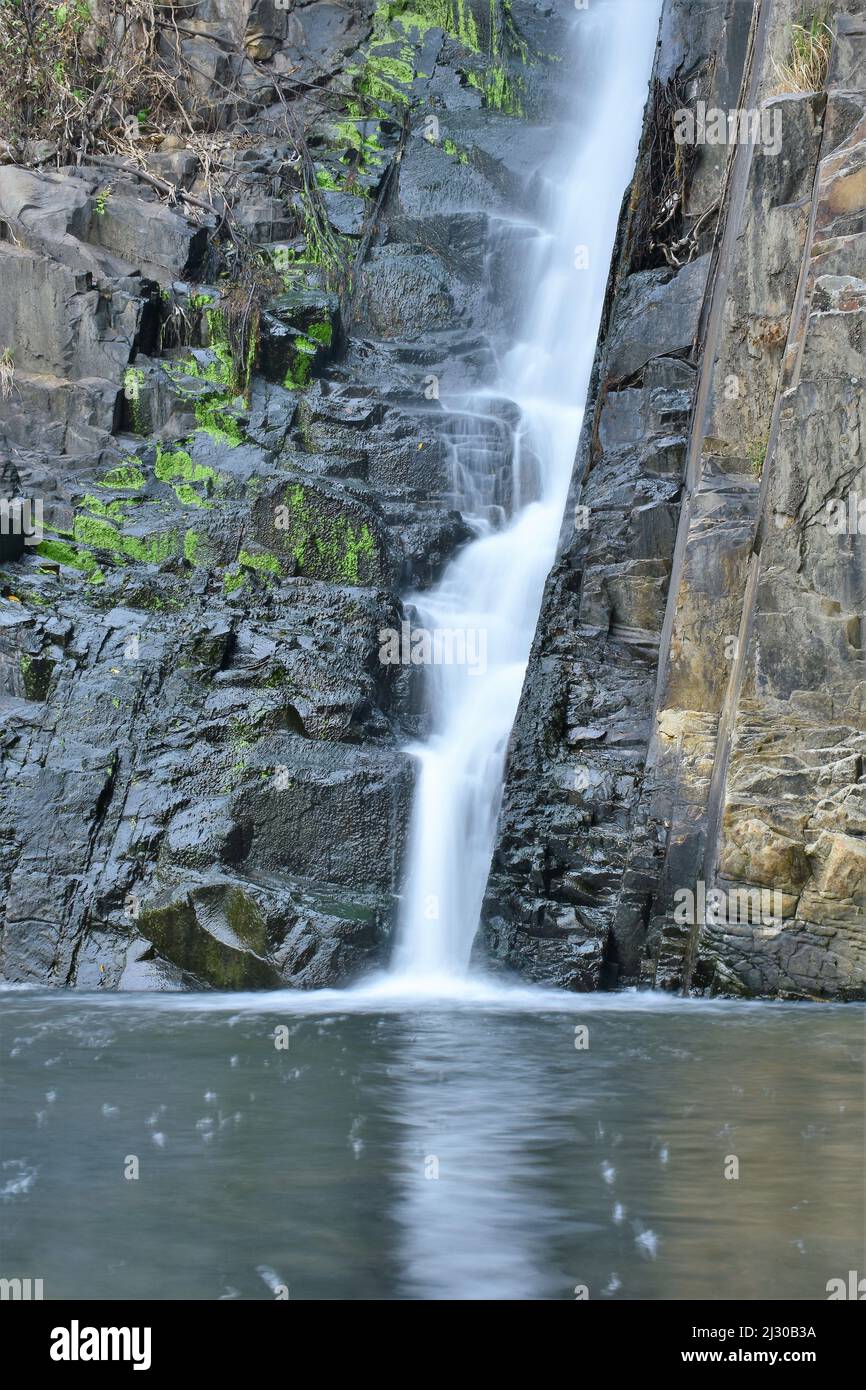 A vertical shot of water flowing between stones Stock Photo - Alamy