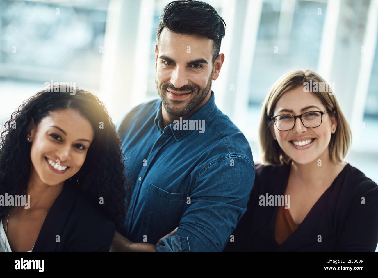 Team number one. Portrait of a group of happy colleagues standing ...