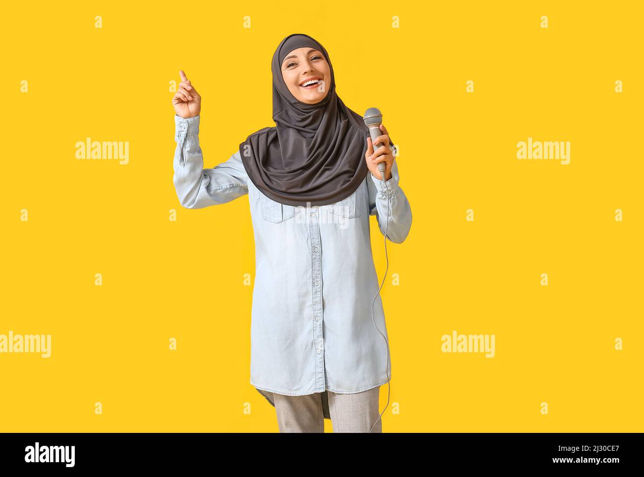 Muslim music teacher with microphone on color background Stock Photo ...