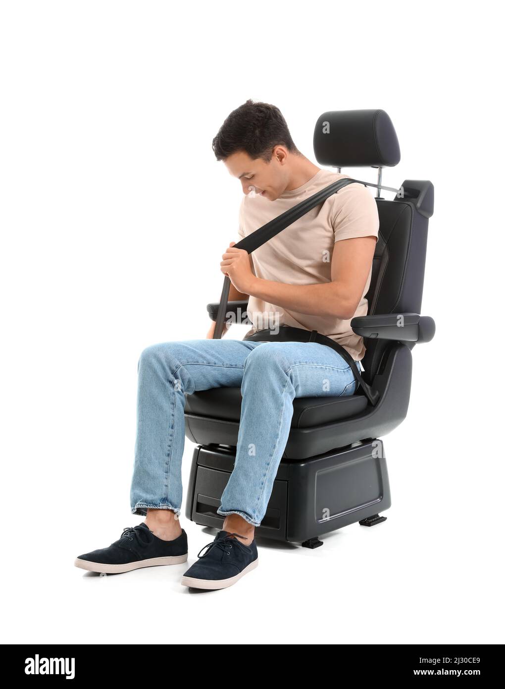 Young man fastening in car seat on white background Stock Photo - Alamy