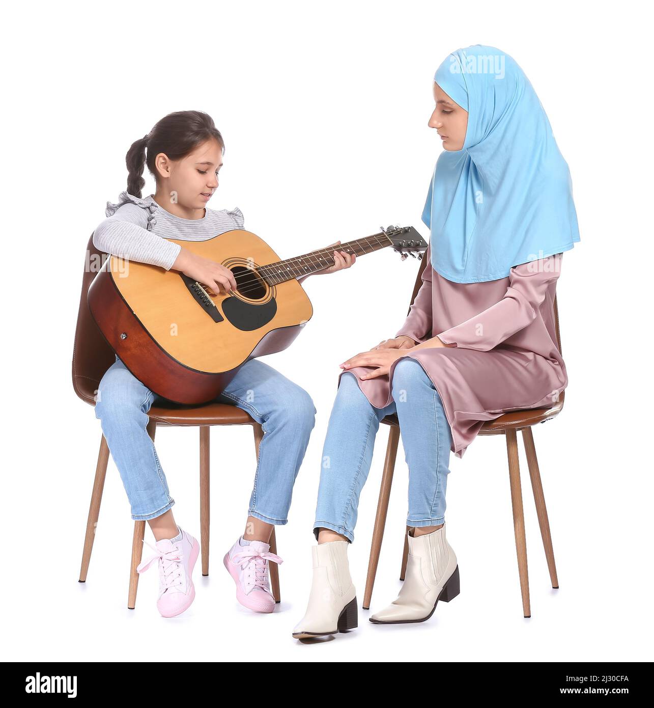 Private Muslim music teacher giving guitar lesson to little girl on ...