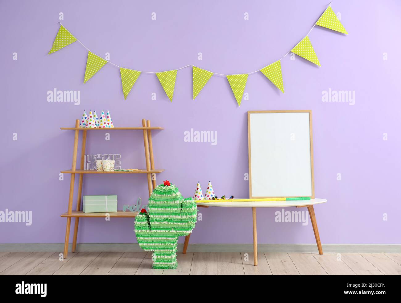 Interior of stylish room with table, shelving unit and Mexican pinata ...