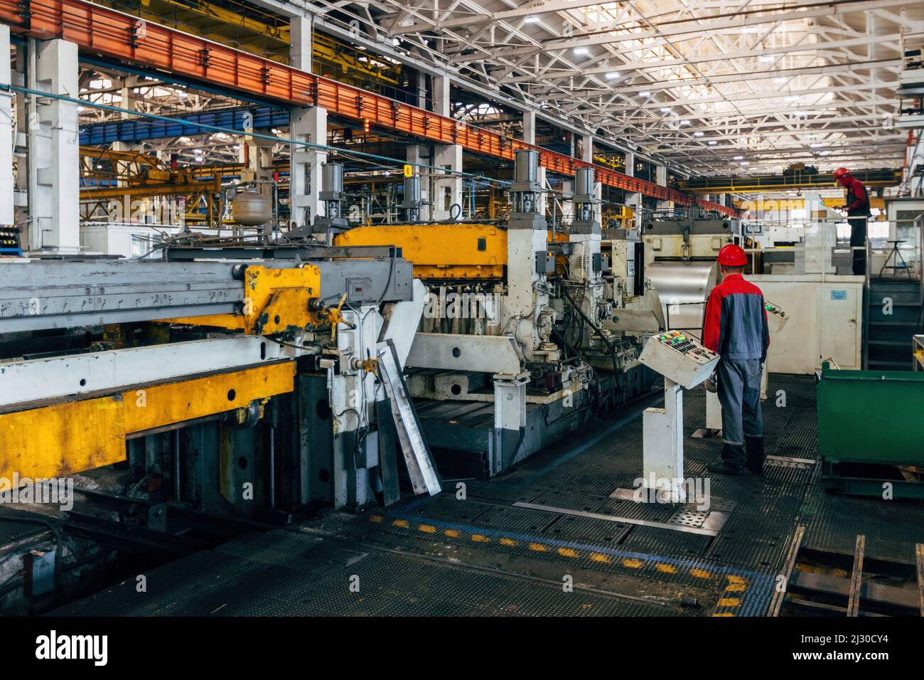 Workers and industrial machinery at metalworking factory production ...