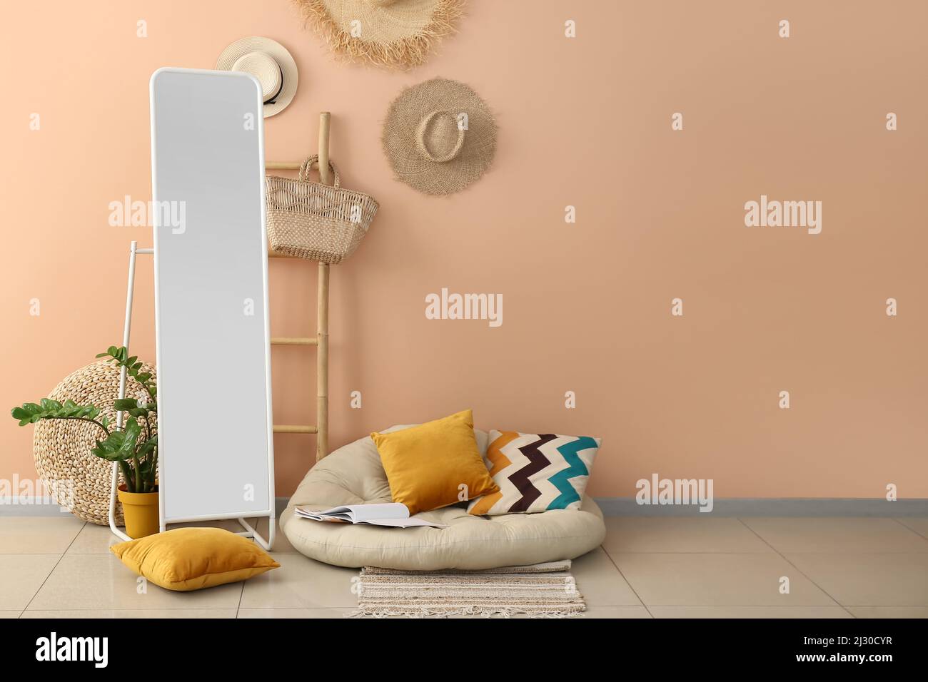 Interior of room with mirror, pouf and pillows near color wall Stock ...