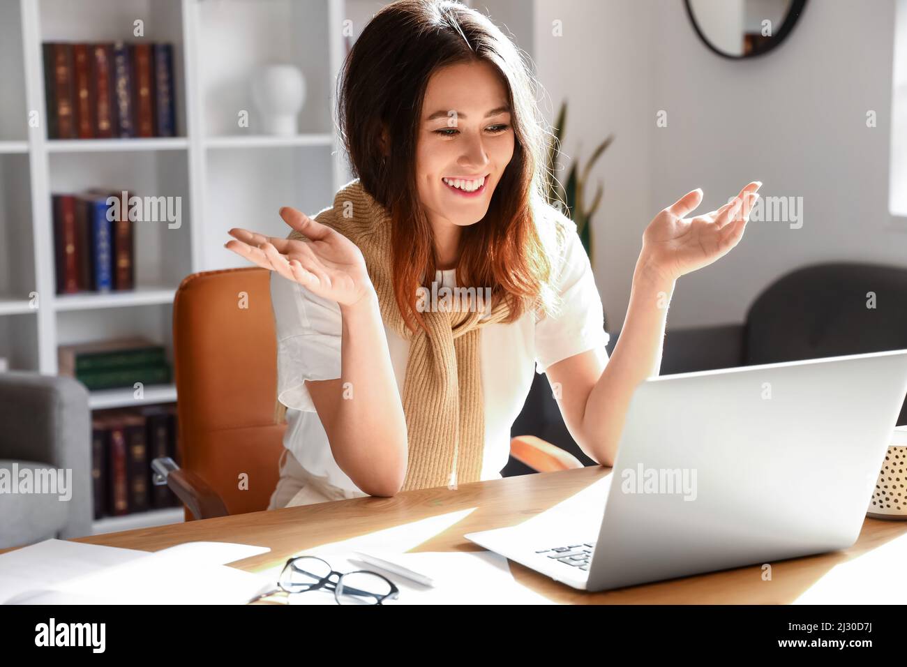 Young Asian tutor with laptop giving lesson online at home Stock Photo ...