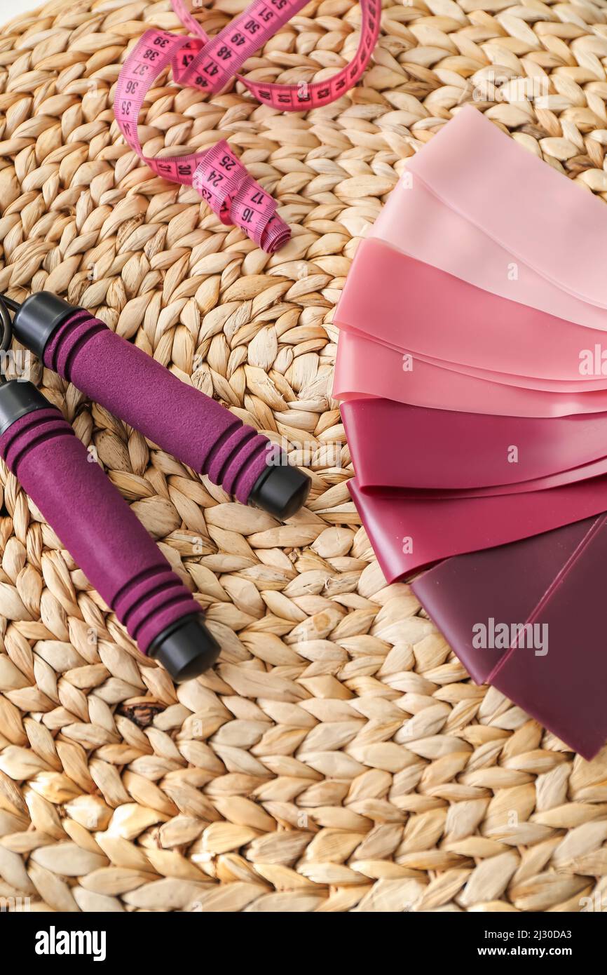 Skipping rope with elastic bands and measuring tape on rattan pouf ...