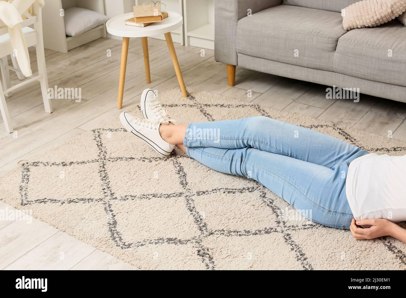 Young woman lying on soft carpet at home Stock Photo - Alamy