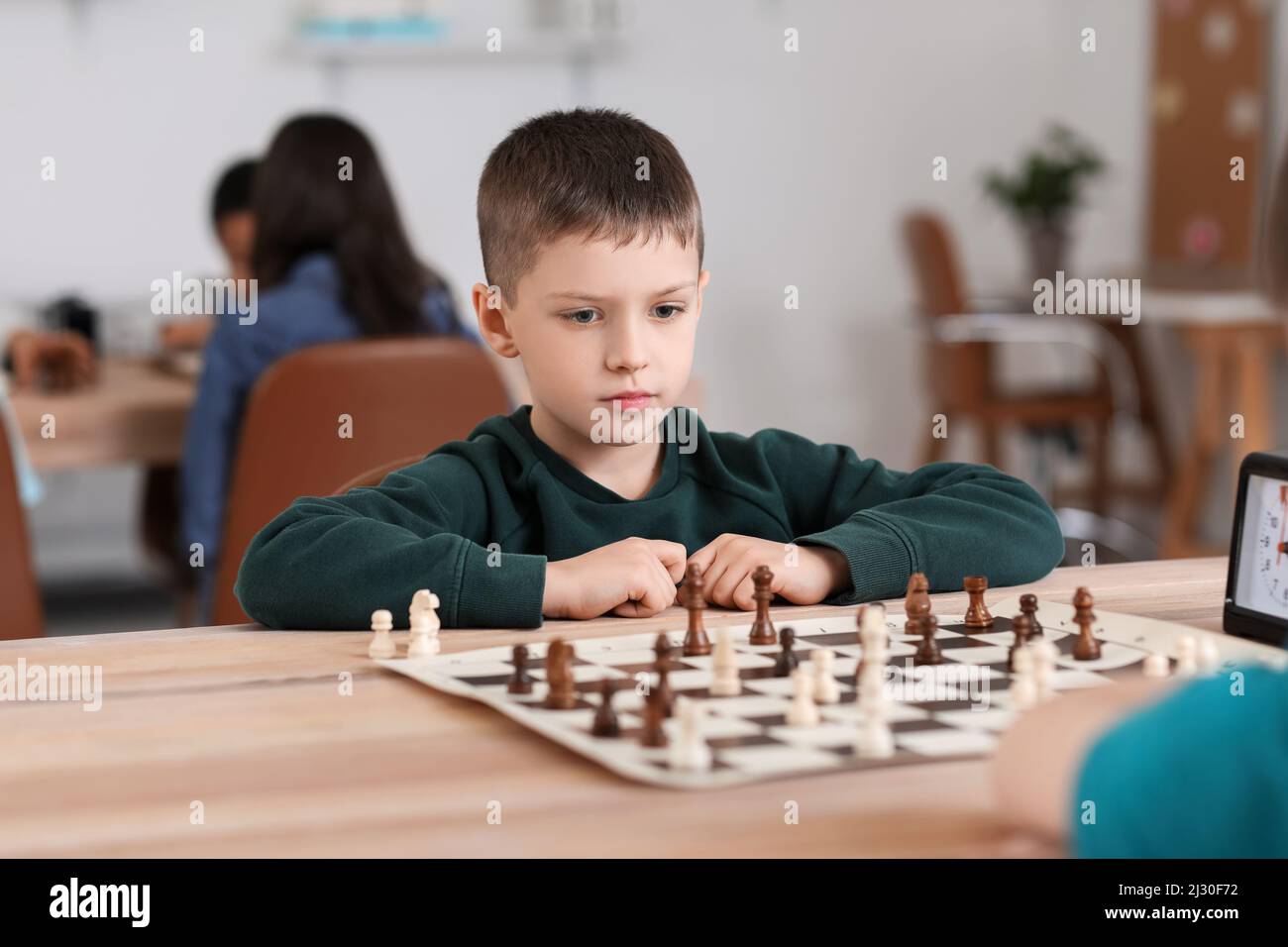 Little boy playing chess during tournament in club Stock Photo - Alamy