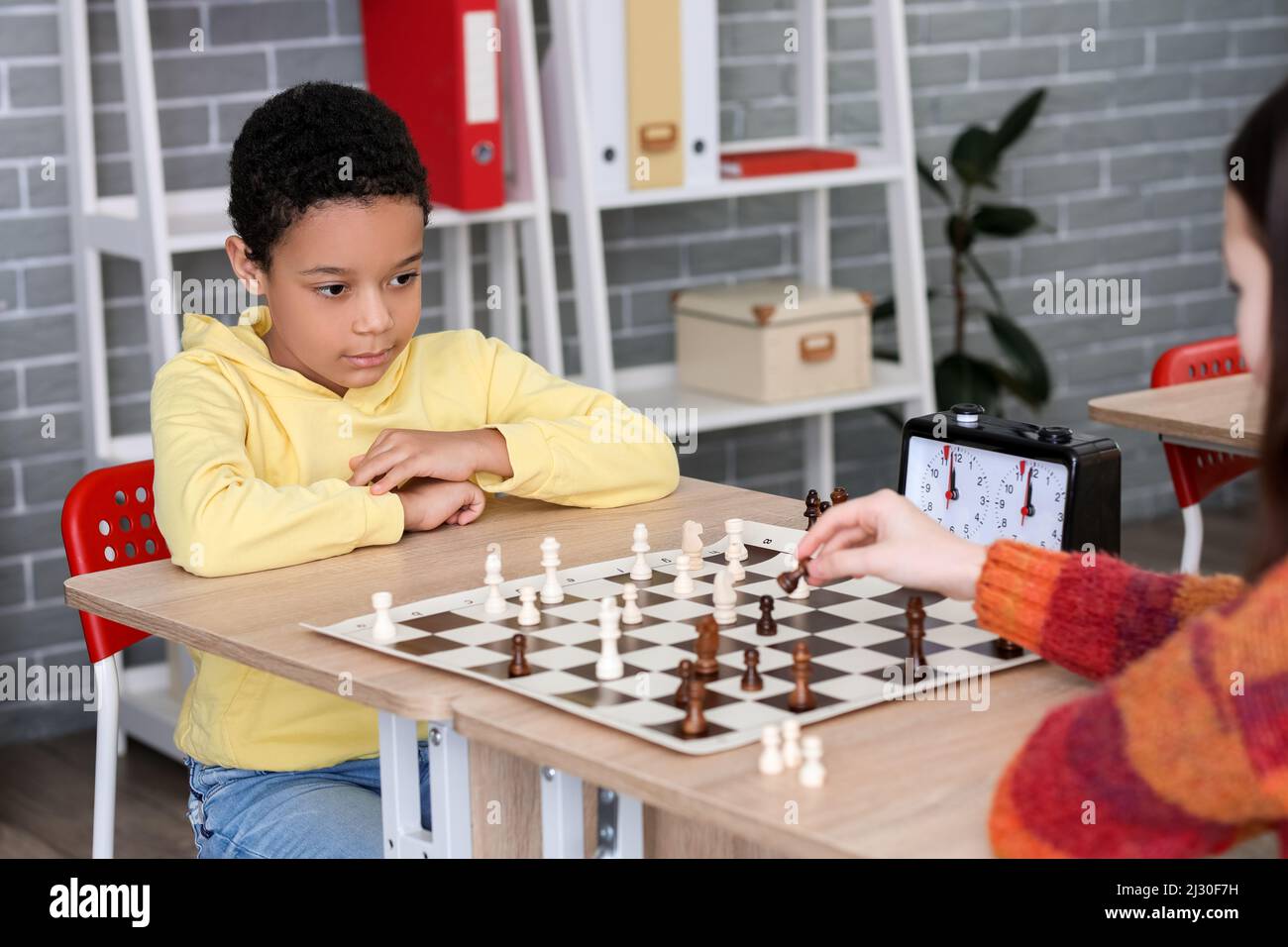 Little children playing chess during tournament in club Stock Photo - Alamy