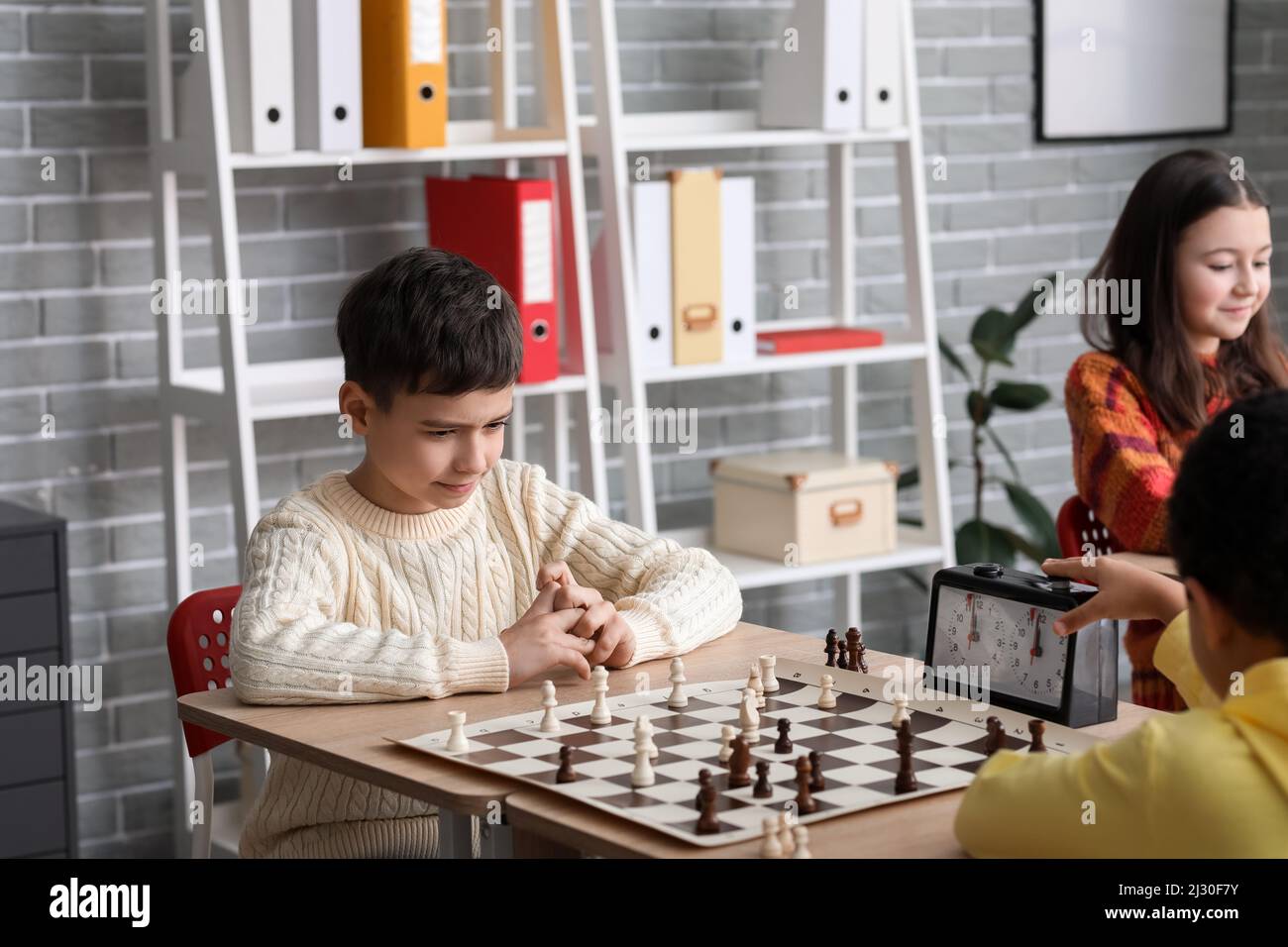 Little children playing chess during tournament in club Stock Photo - Alamy