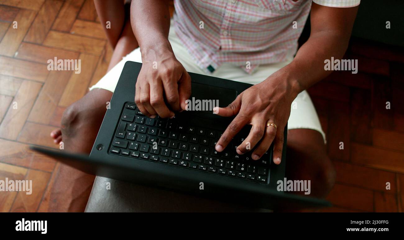 Black father browsing internet on laptop with child son Stock Photo - Alamy