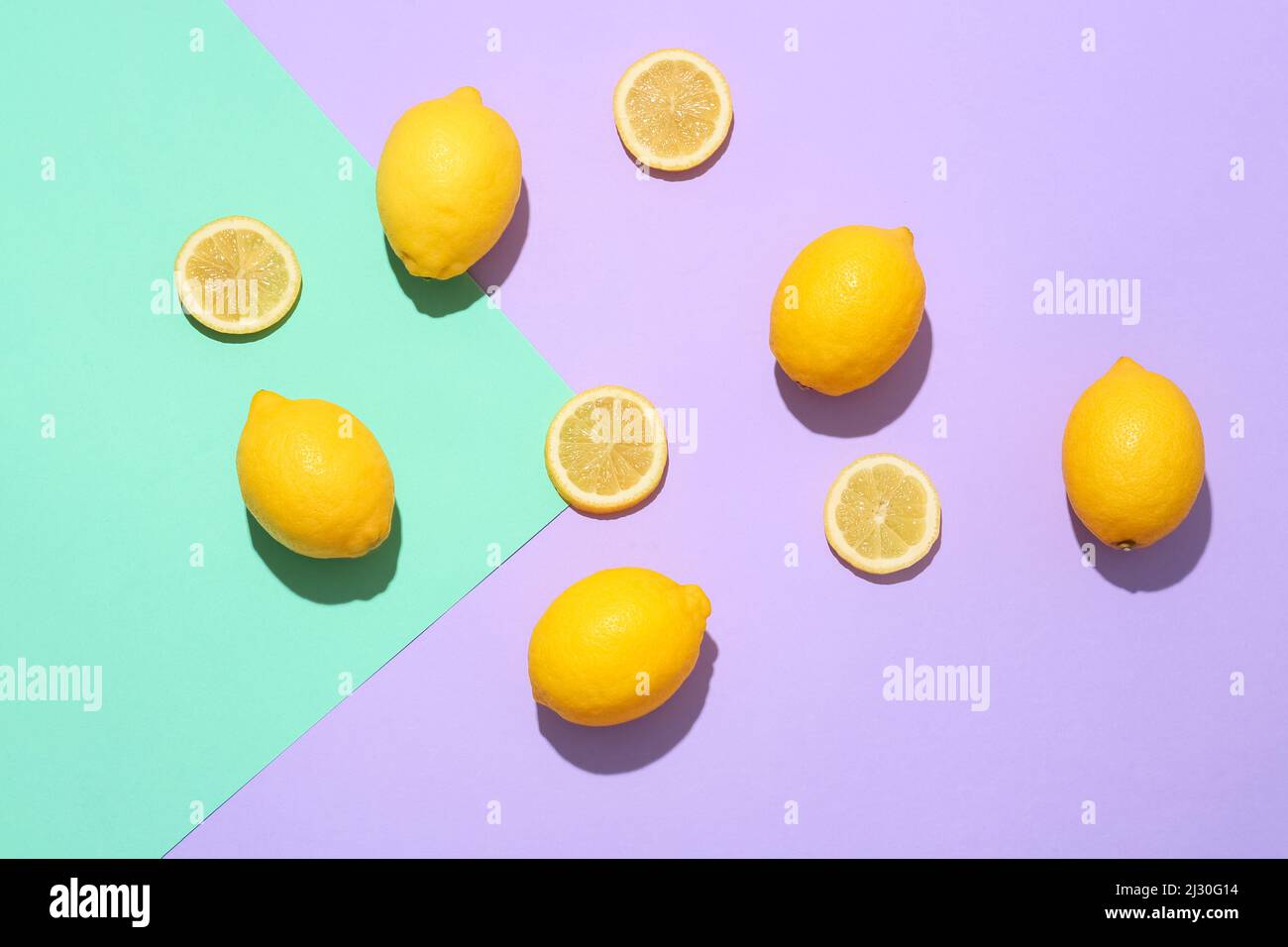 Ripe lemons and slices on color background, top view Stock Photo - Alamy