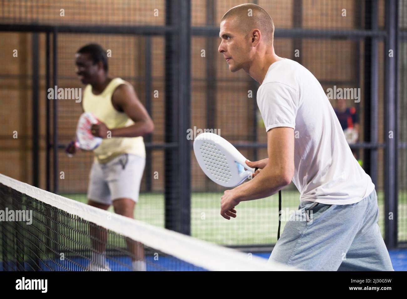 Concentrated paddle tennis player preparing to hit forehand Stock Photo ...