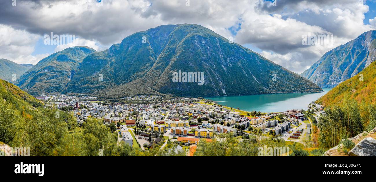 A panoramic shot of houses and fjord surrounded by mountains in ...