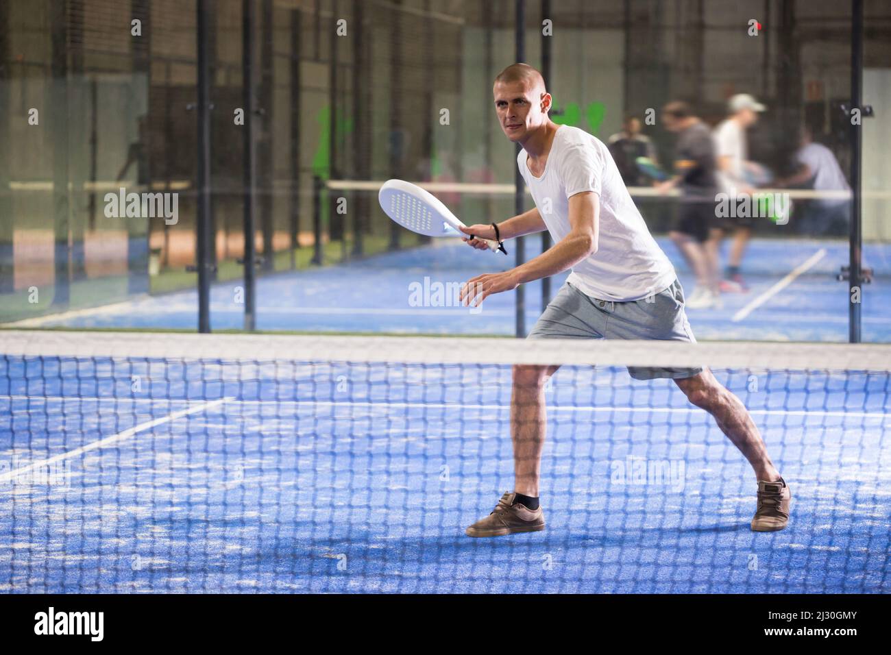 Concentrated paddle tennis player preparing to hit forehand Stock Photo ...