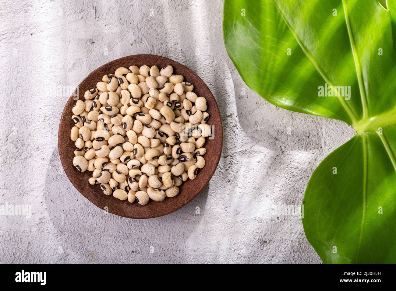 pile of black-eyed beans, in container on concrete surface- lubiya ...