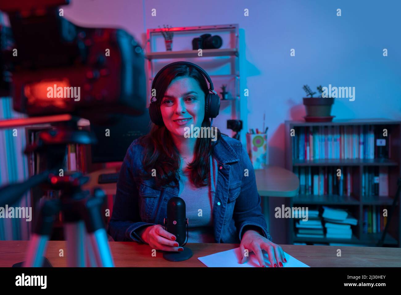 Beautiful Hispanic woman in front of a video camera recording a blog in ...