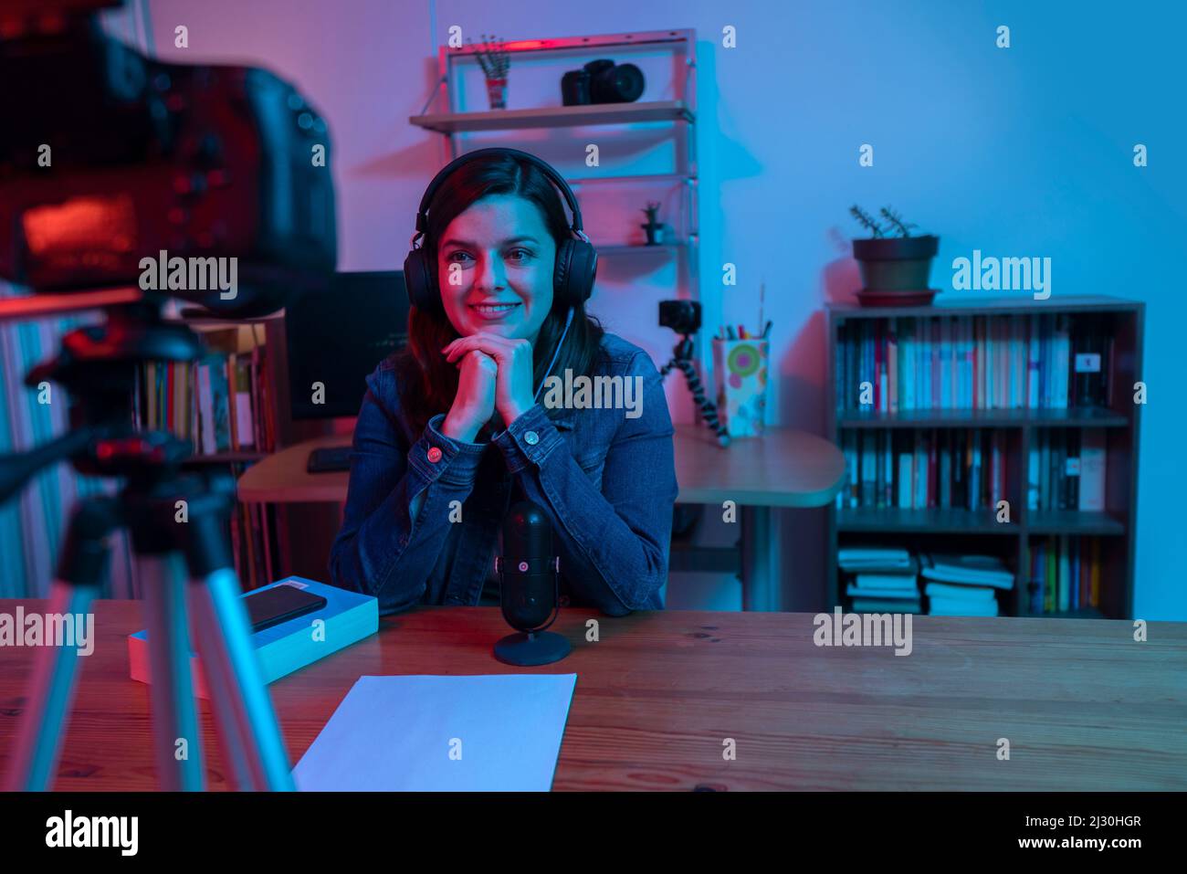 Beautiful Hispanic woman in front of a video camera recording a blog in ...