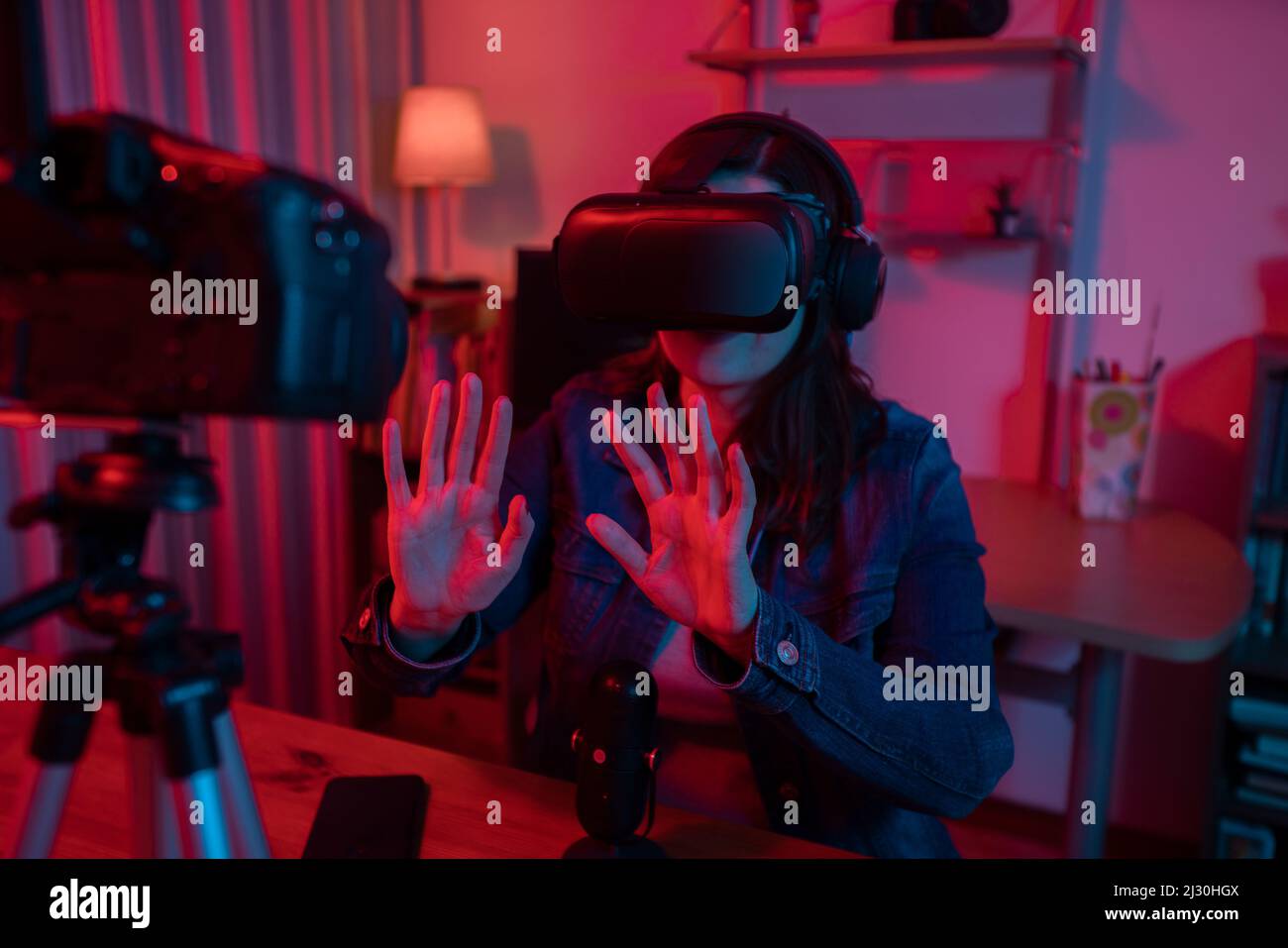 Beautiful Hispanic woman in front of a video camera recording a blog in ...