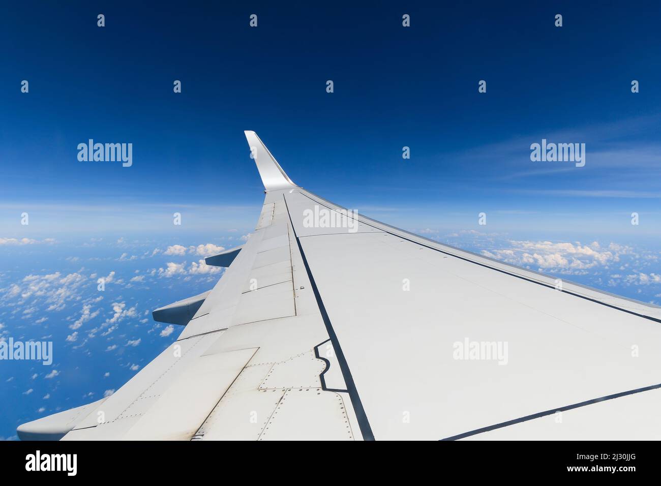 View of the wing of a white airplane during a flight on a beautiful ...