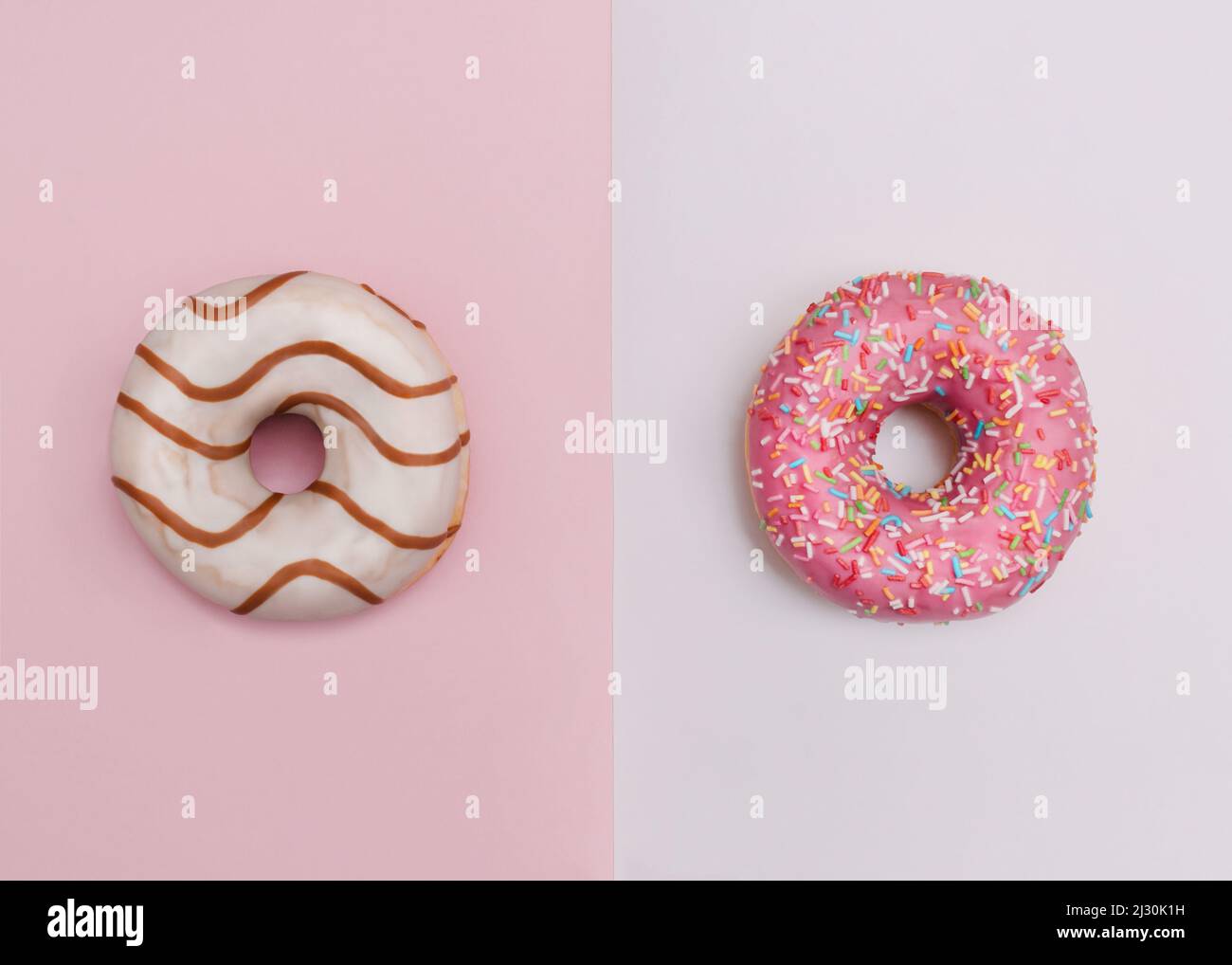 Ring doughnuts with icing and sprinkles on two-tone backdrop Stock ...