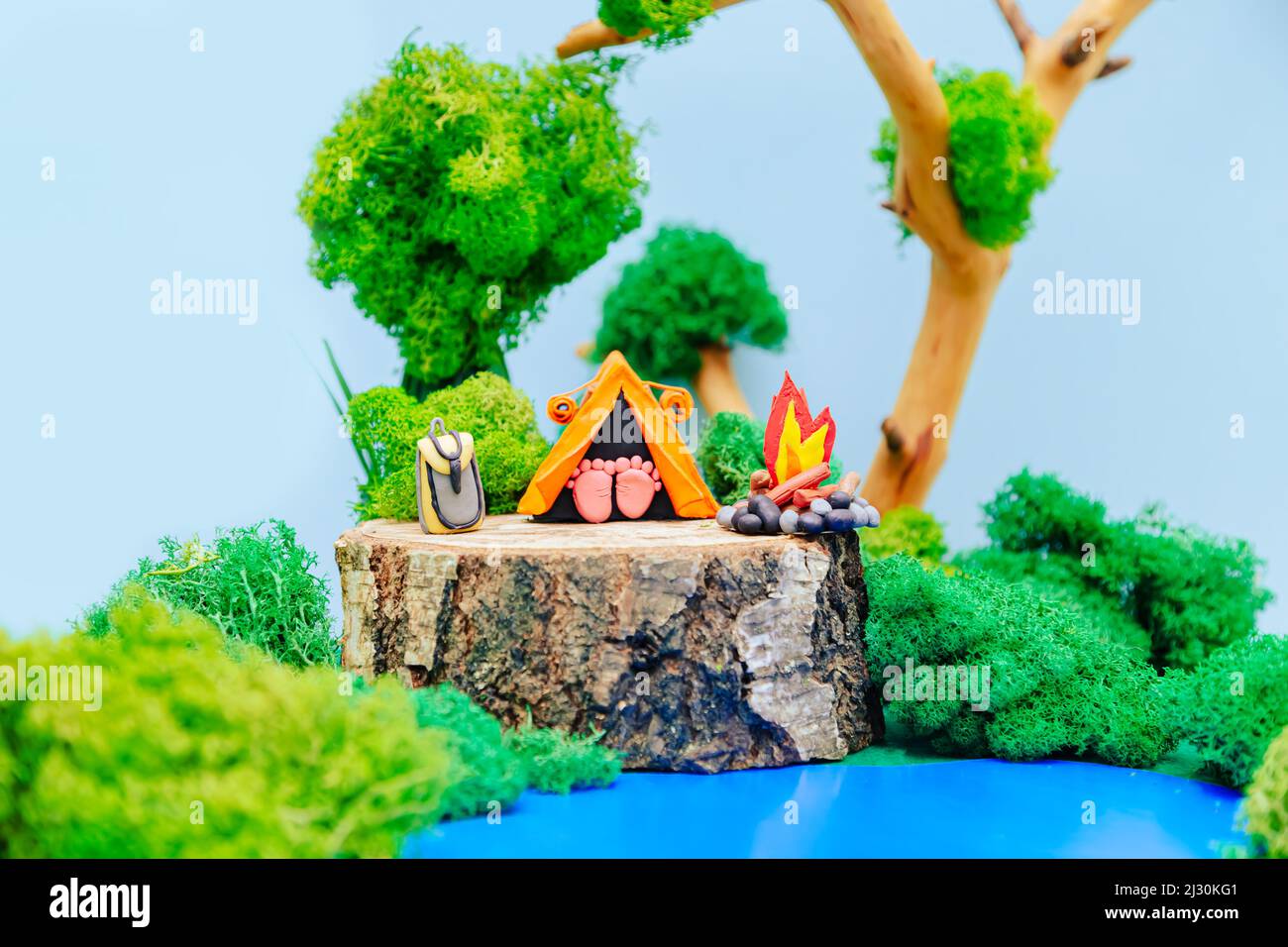 Tourist camp. Plasticine landscape with a tent, a campfire and a ...