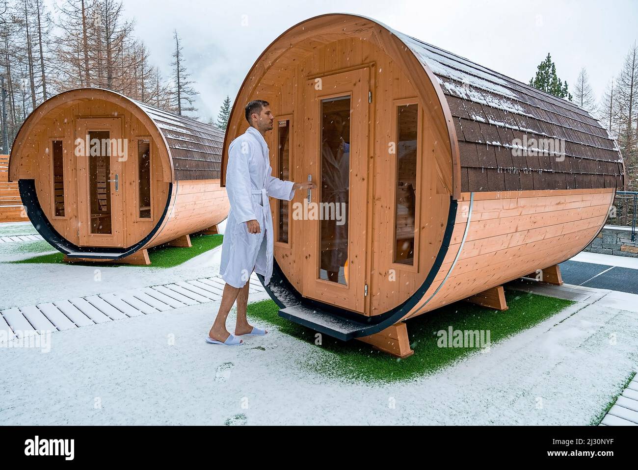 Tourist entering round sauna room during winter snowfall Stock Photo ...
