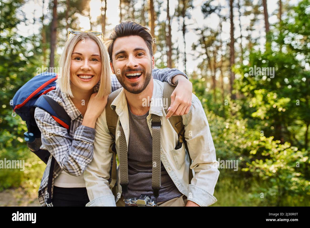 Portrait of laughing couple hiking together in the woods Stock Photo ...