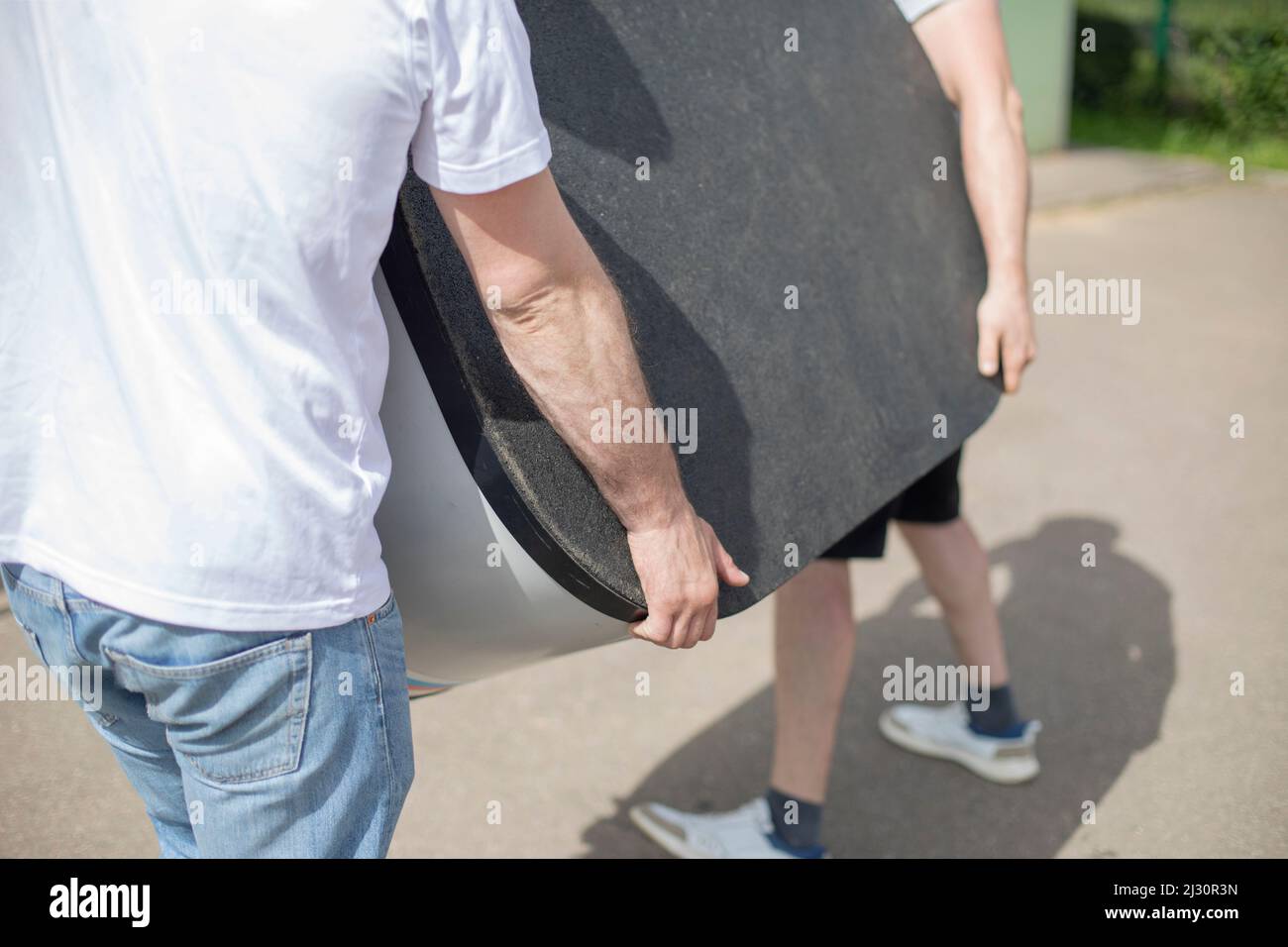 The movers are dragging the table. Men carry the burden. Carrying ...