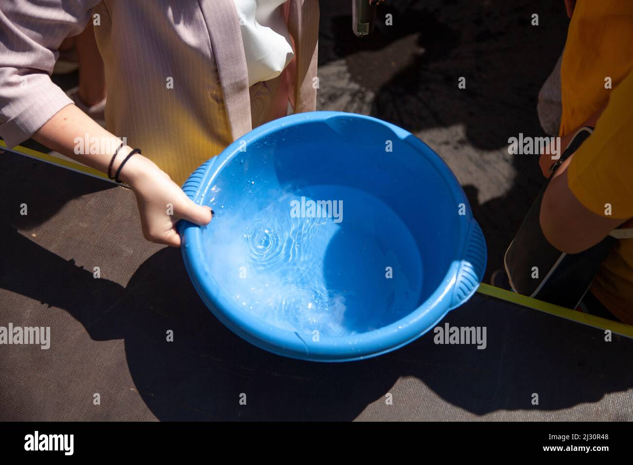 Water in the container. Blue basin with water. Experiment with dry ice ...