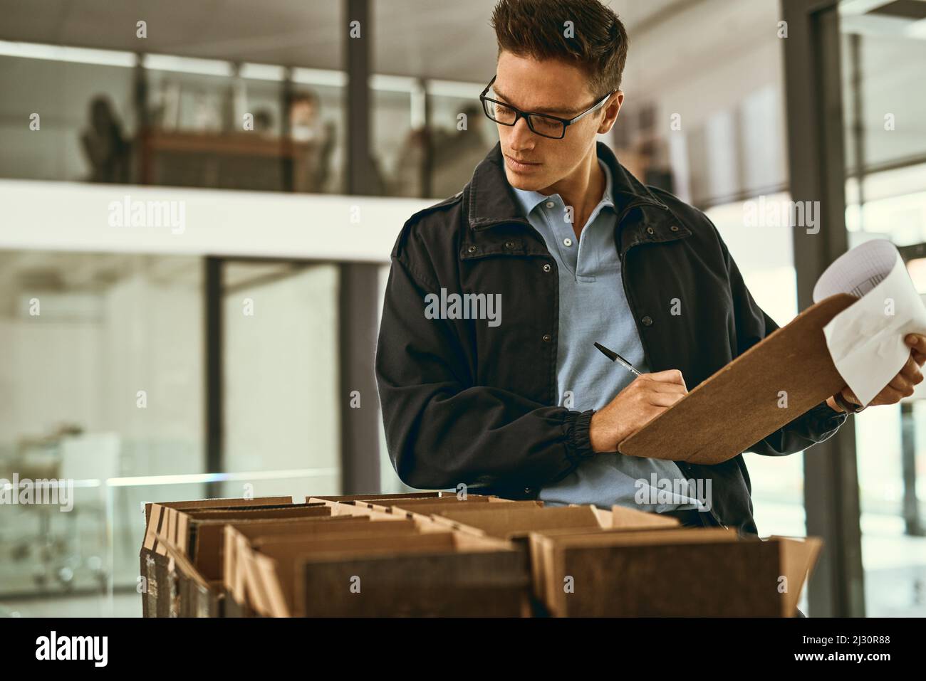 Getting packages on their way. Shot of a courier sorting through boxes ...