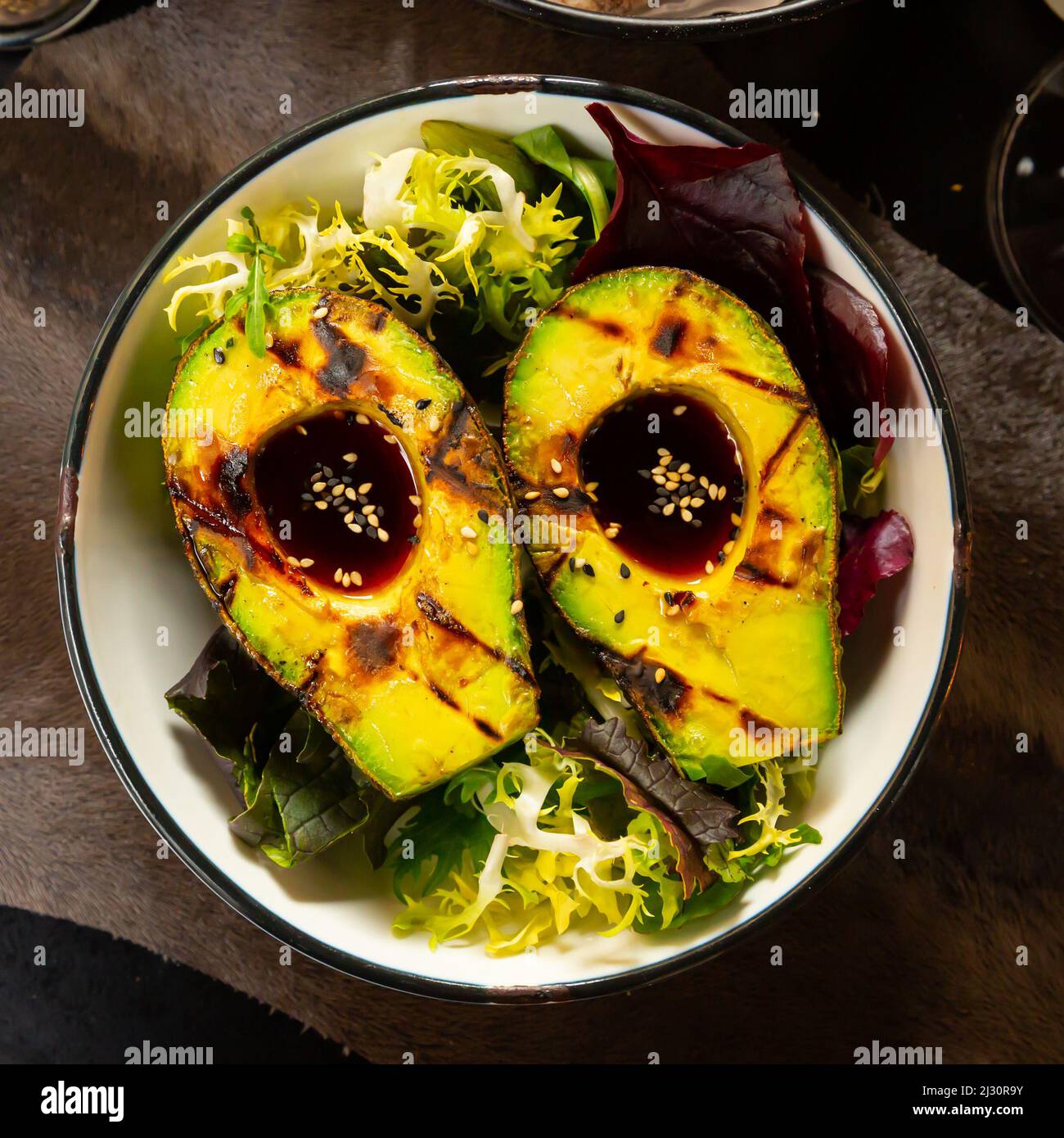 Baked avocados with sesame seeds and vegetables Stock Photo - Alamy