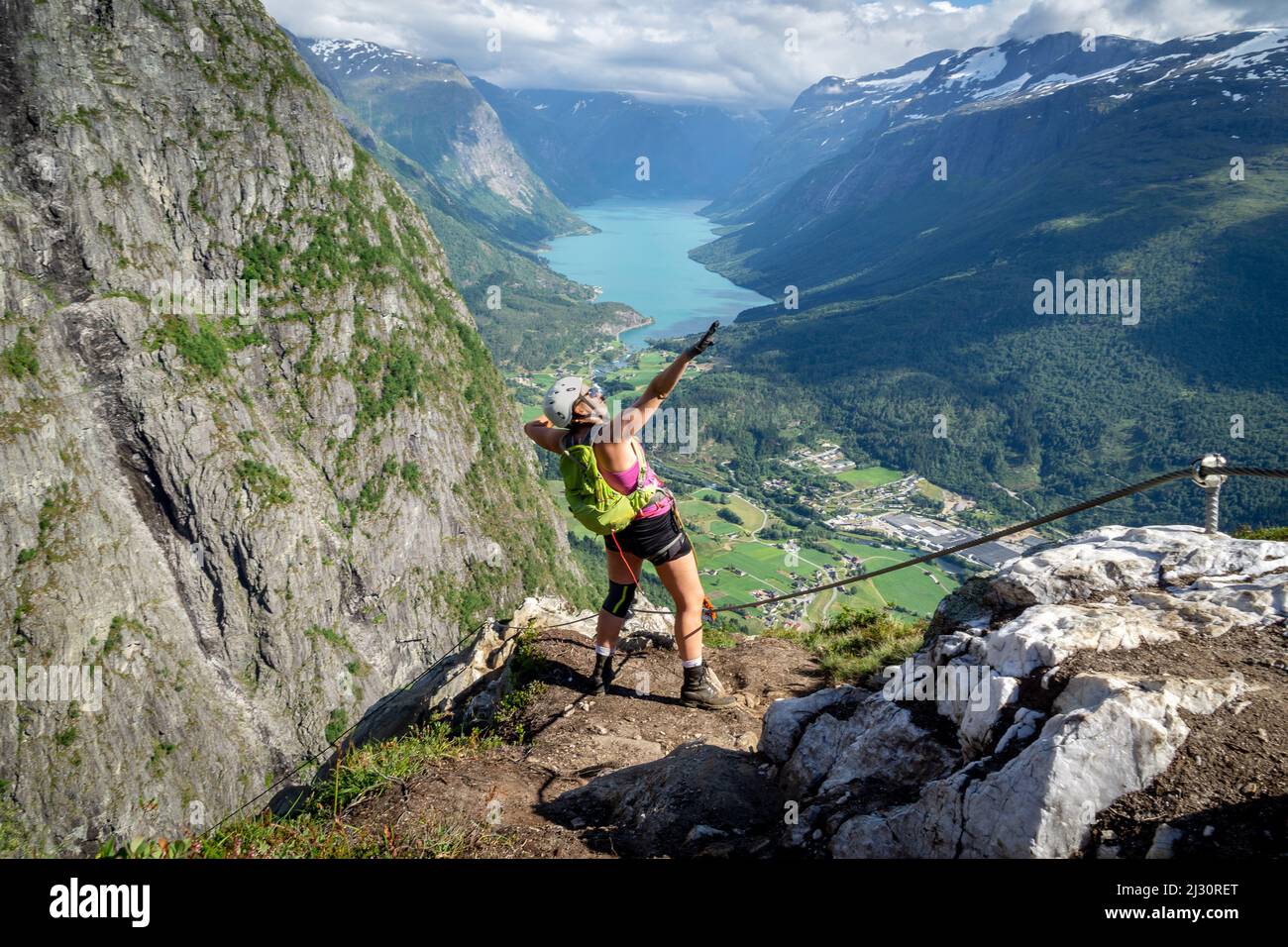 A Caucasian female posing at the edge of rock cliff overlooking scenic ...