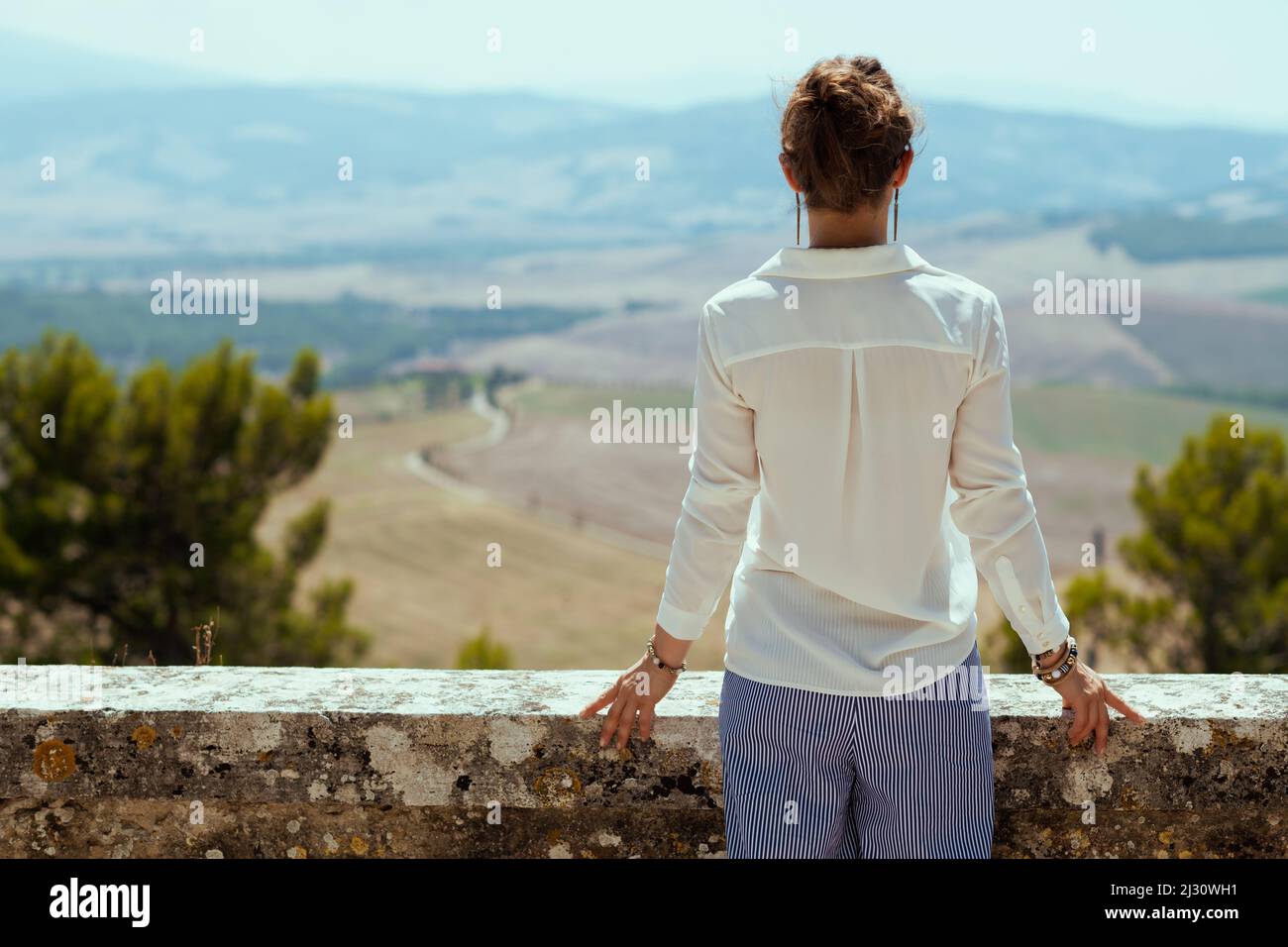 Travel in Italy. Seen from behind modern woman in Pienza in Tuscany ...