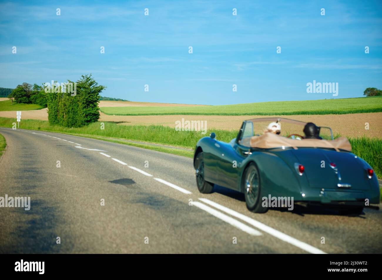 Defocused view of rear view couple inside vintage green unrecognizable ...