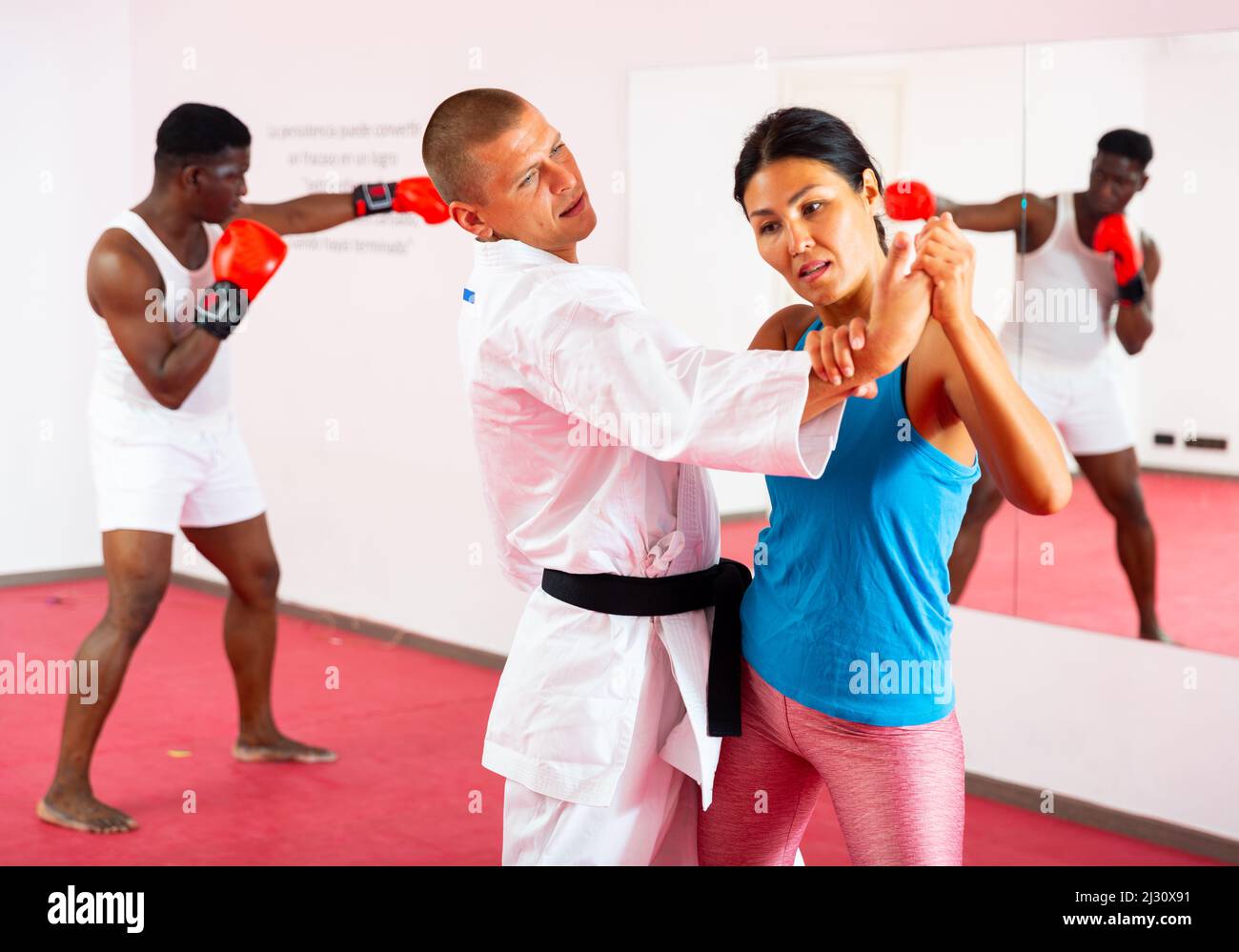 Woman is practicing self-defence fight in pair with trainer in gym ...