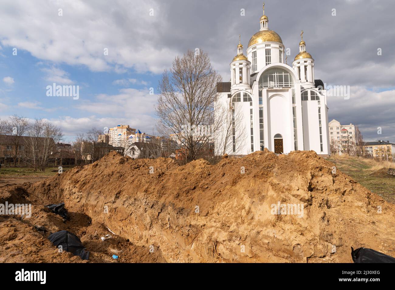 Bucha, Ukraine. 04th Apr, 2022. A grave is seen behind the Church of St ...