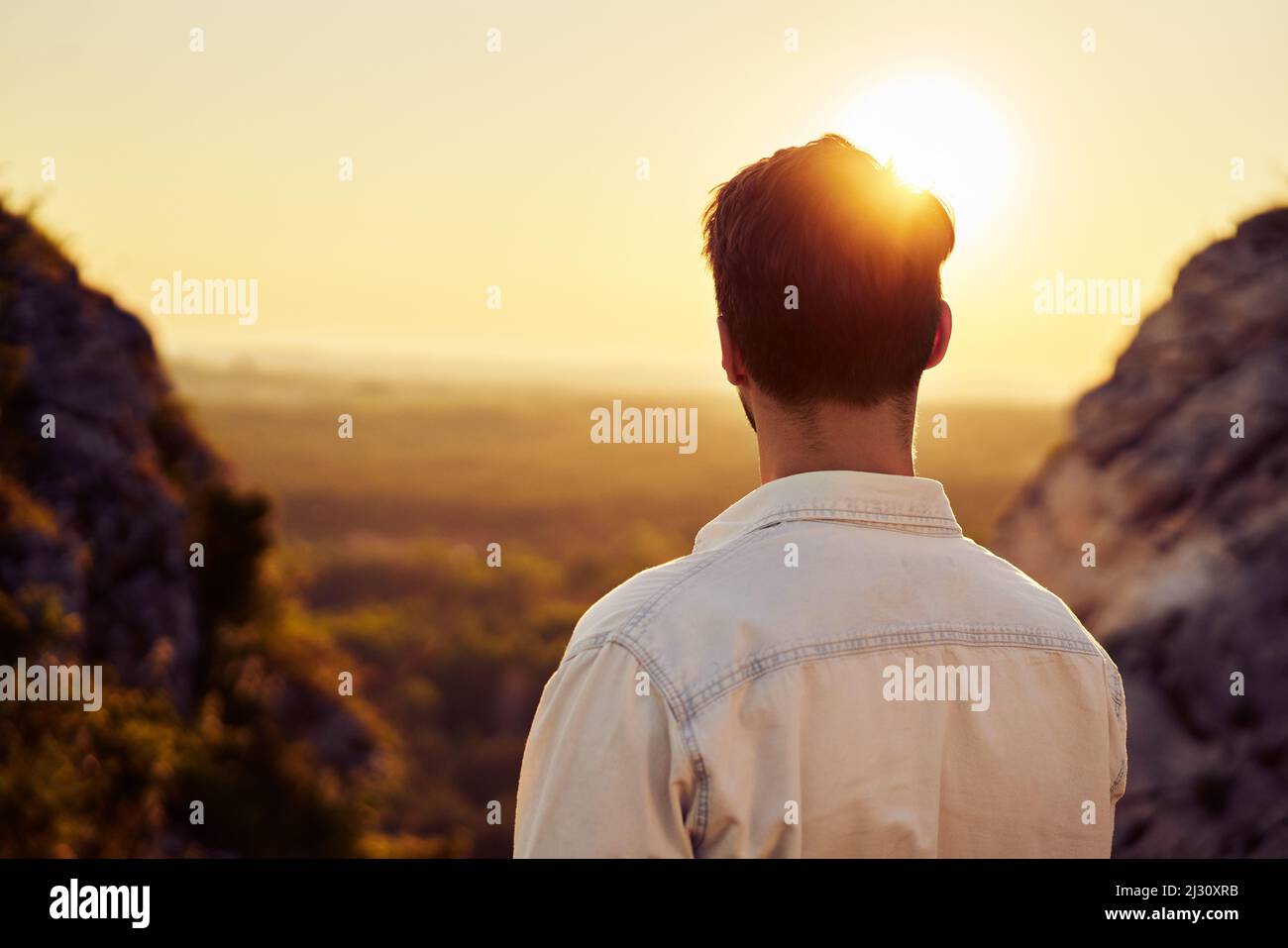 Back of a man watching sunset hiking in mountains Stock Photo - Alamy