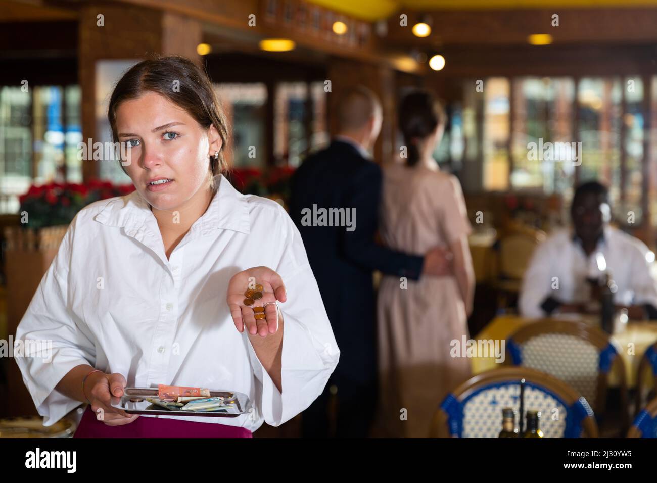 Waitress disappointed in small tip from guests Stock Photo - Alamy