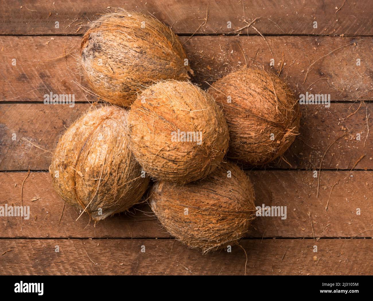 coconut, healthy tropical fruits without husk on a wooden table top ...